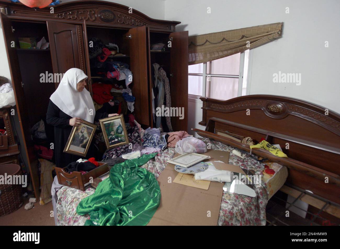 Palestinian Asmaa Abu El-Heija holds pictures of two of her sons as she ...