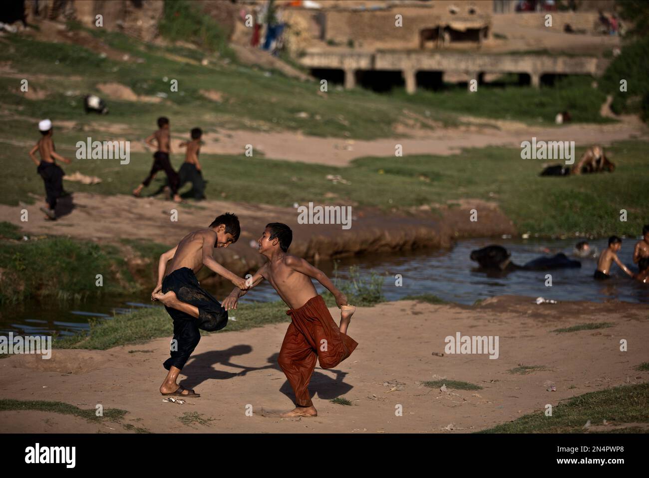 Afghan refugee boys, play a traditional fighting game, on the outskirts ...