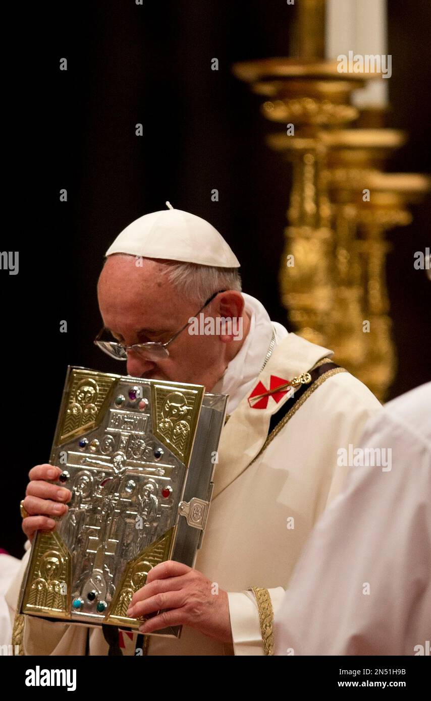 Pope Francis kisses the Holy Gospel as he celebrates the Easter vigil ...