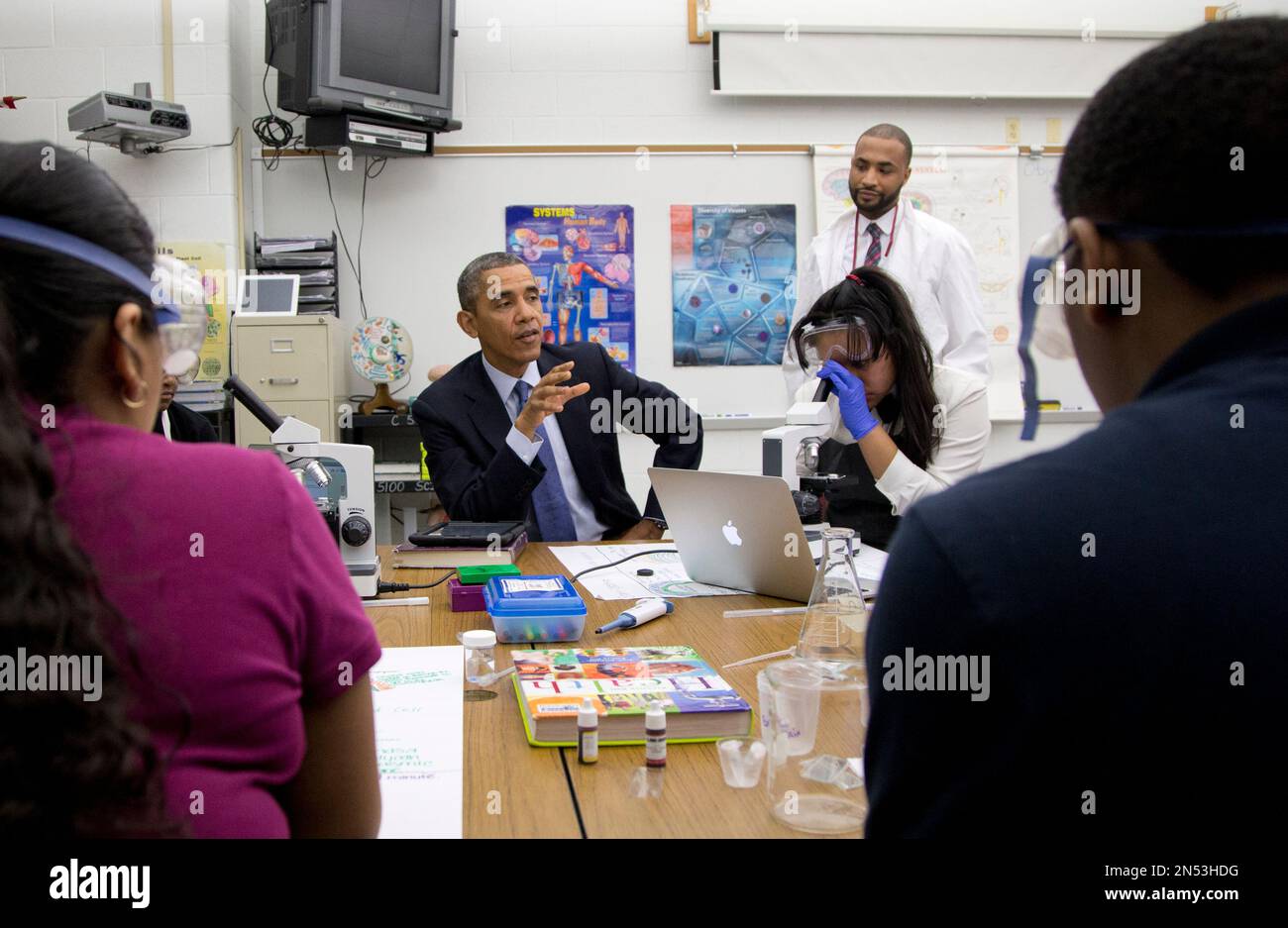 President Barack Obama talks to a student as he visits a classroom at ...