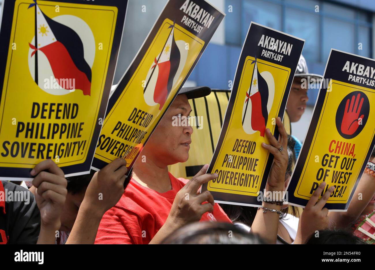 Protesters display placards and a mock tape measure during a rally ...