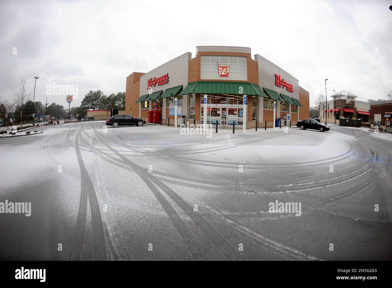 In this photo taken with a fisheye lens, snow covers the parking area ...