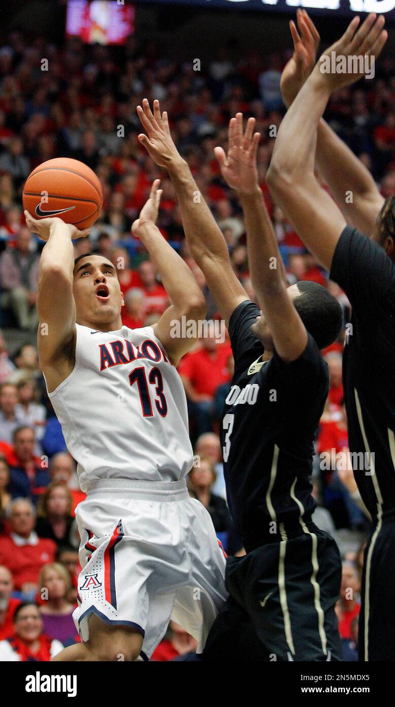 Arizona's Nick Johnson (13) shoots for two against the defense of ...