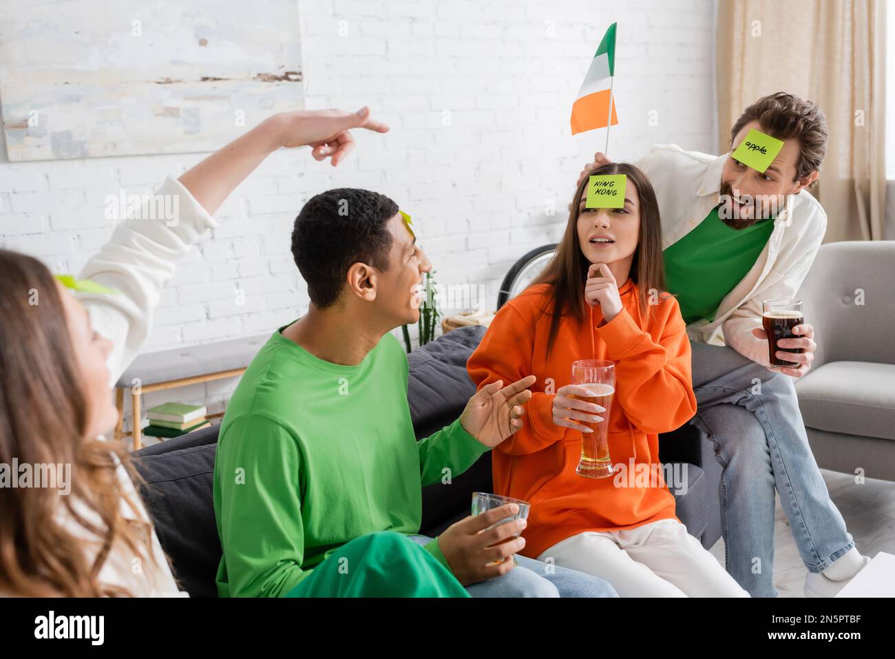 Femme pointant vers des amis avec des notes collantes sur les fronts ...