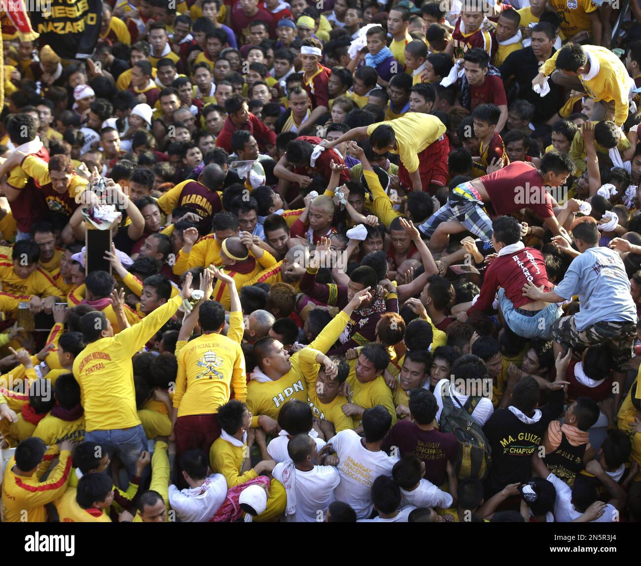 Filipino Catholic devotees climb a carriage to touch and kiss the image ...
