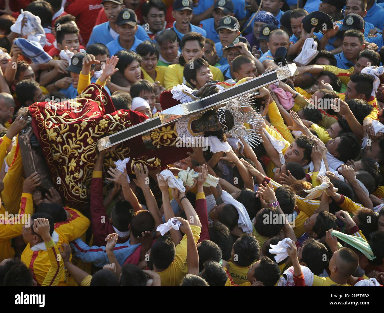 Filipino Catholic devotees reach out to touch the image of the Black ...