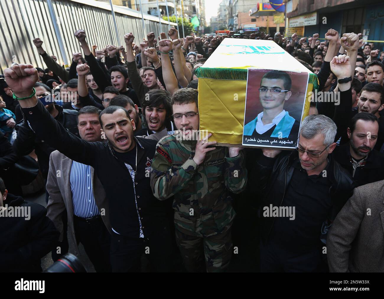 Mourners raise up their hands and shout religion slogans, as others ...