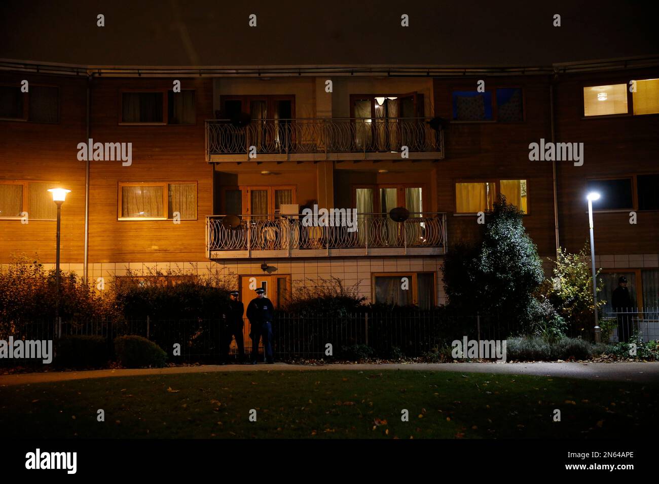 Police officers stand outside properties as police conduct house-to ...