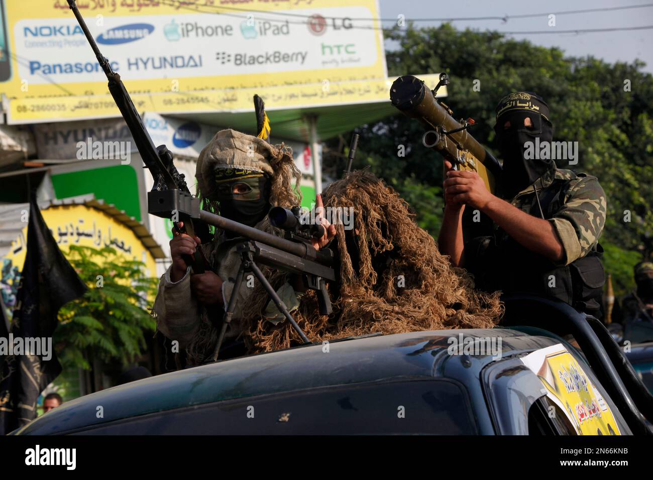 Palestinian Islamic Jihad militants sit behind a machine gun on a truck ...