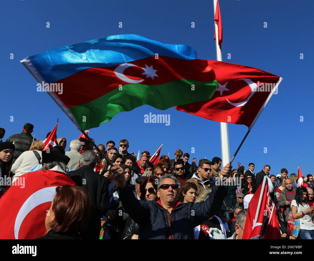 A man waves an Azeri, left, and a Turkish flags as thousands of people ...