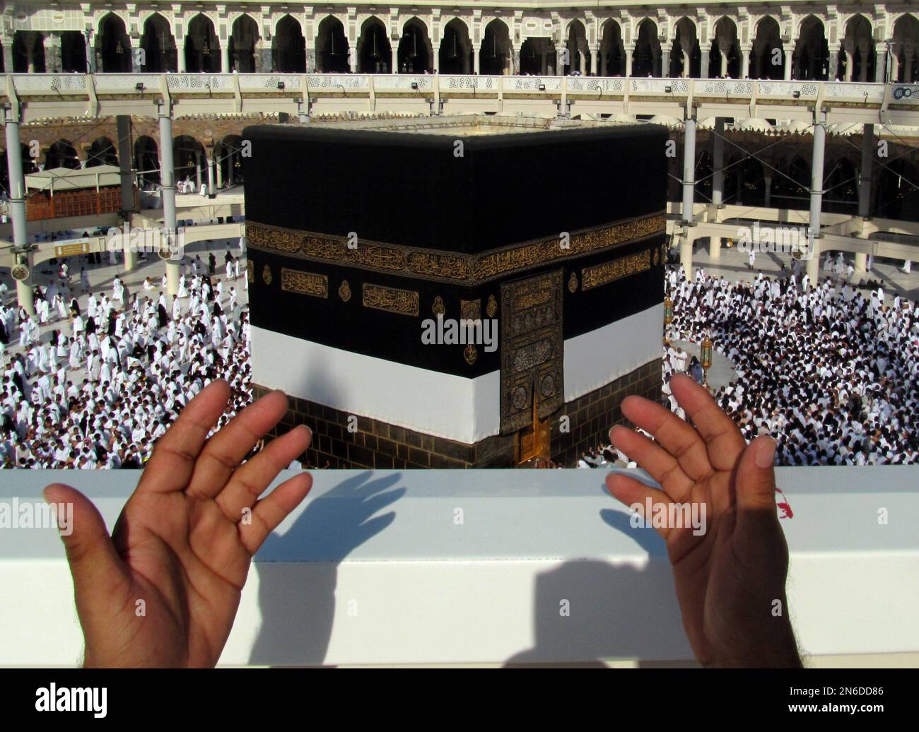 A Muslim pilgrim prays in front of the Kaaba, the cube-shaped structure ...