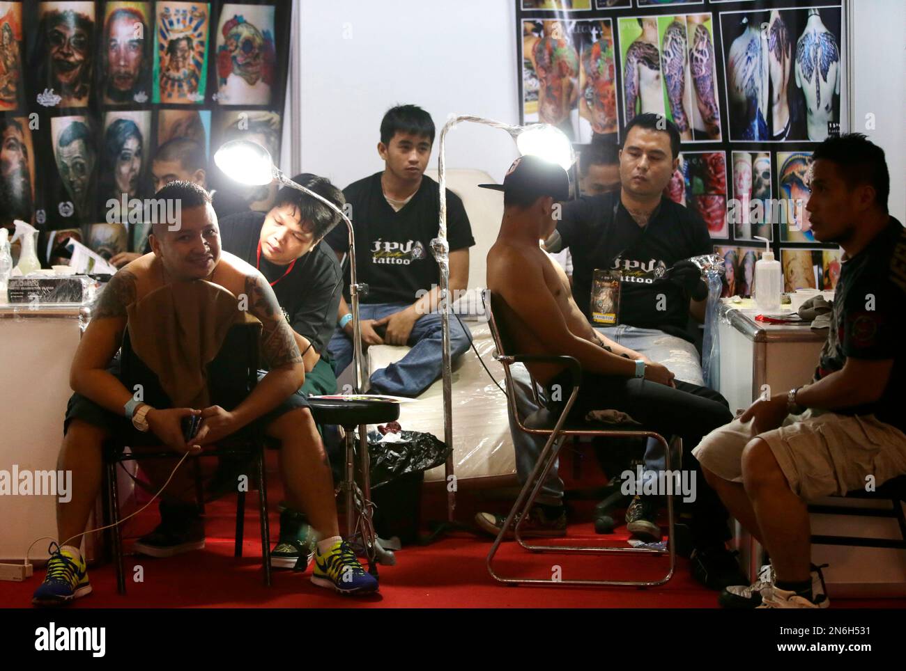 Filipino tattoo artists work on designs for their clients at the ...