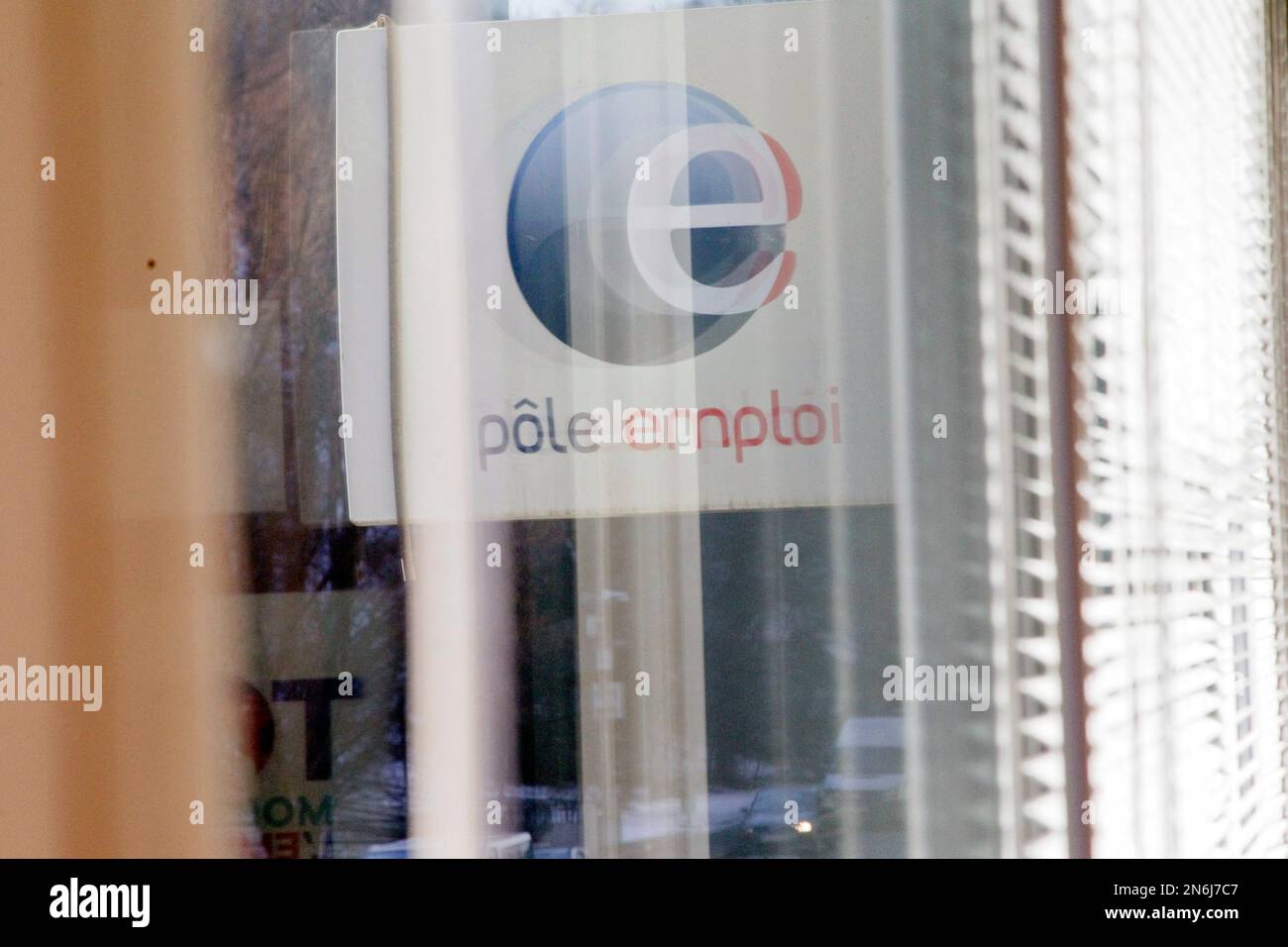 Le logo Pole emploi sur un panneau vu par la fenêtre de l'agence ...