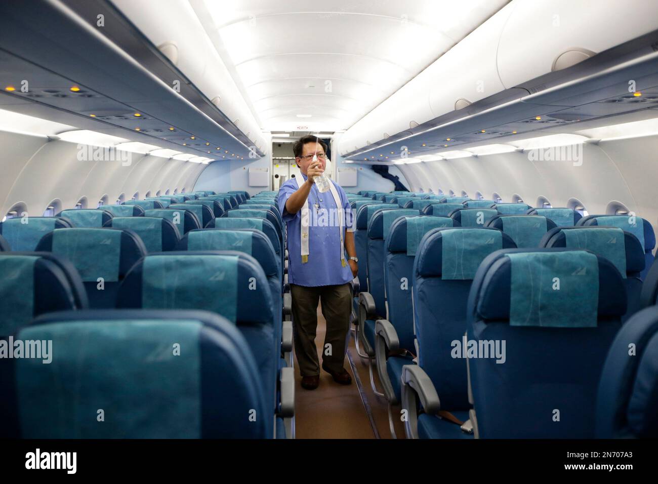 A Roman Catholic priest blesses with holy water the brand new Airbus ...