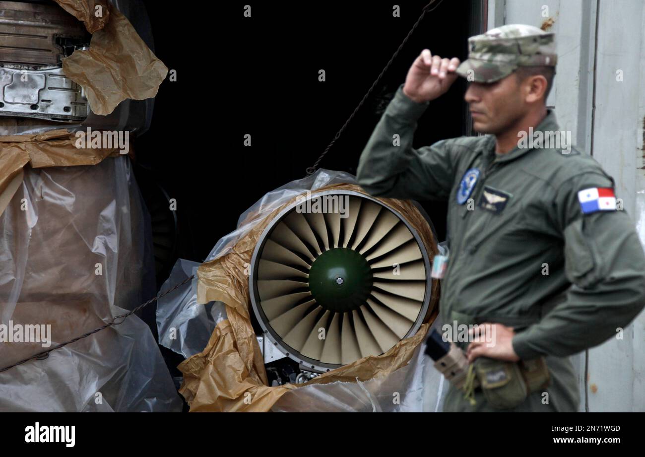 A naval police officer stands in front of a container carrying a ...