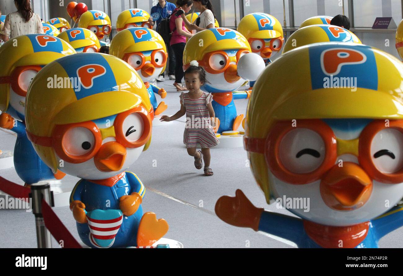 A girl passes by dolls featuring South Korean animation character ...