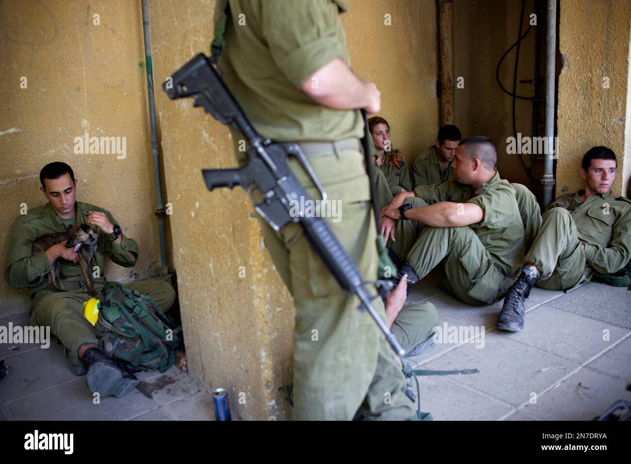 Israeli soldiers of the Home Front Command rescue unit take cover as an ...