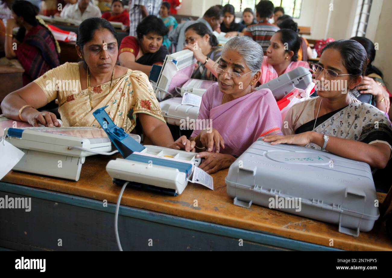 Indian polling officials inspect the performance of electronic voting ...