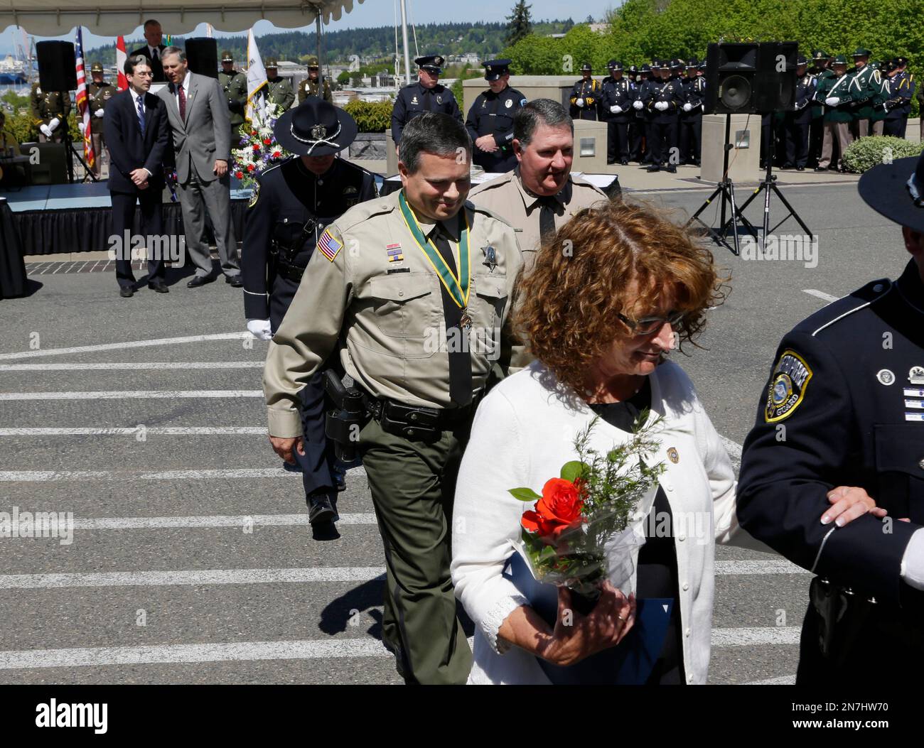 Spokane County Sheriff's Deputy Joseph Spink, center left, walks with ...