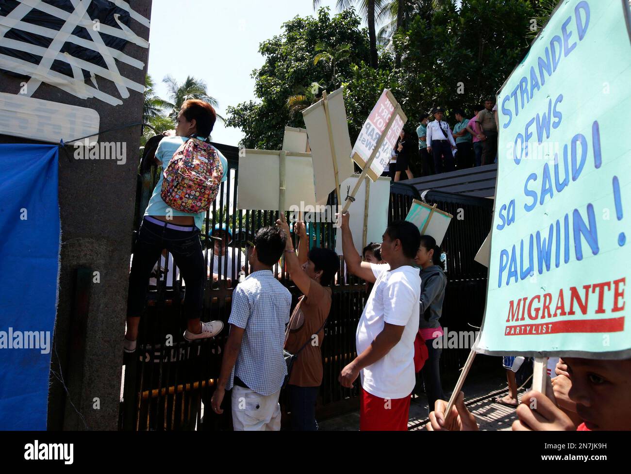 Relatives of OFWs (Overseas Filipino Workers) display placards as they ...