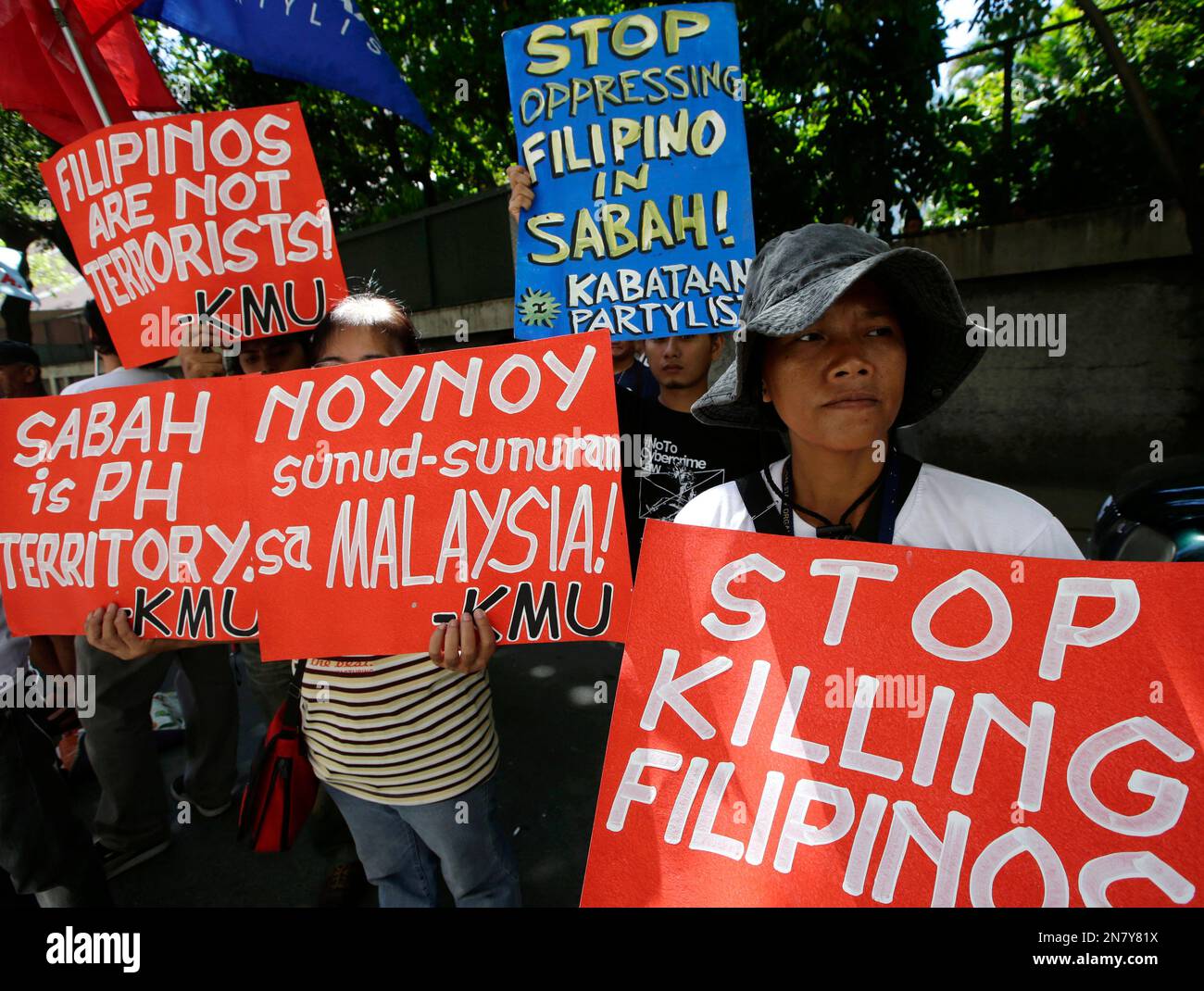 People display placards during a rally outside the Malaysian Embassy at ...