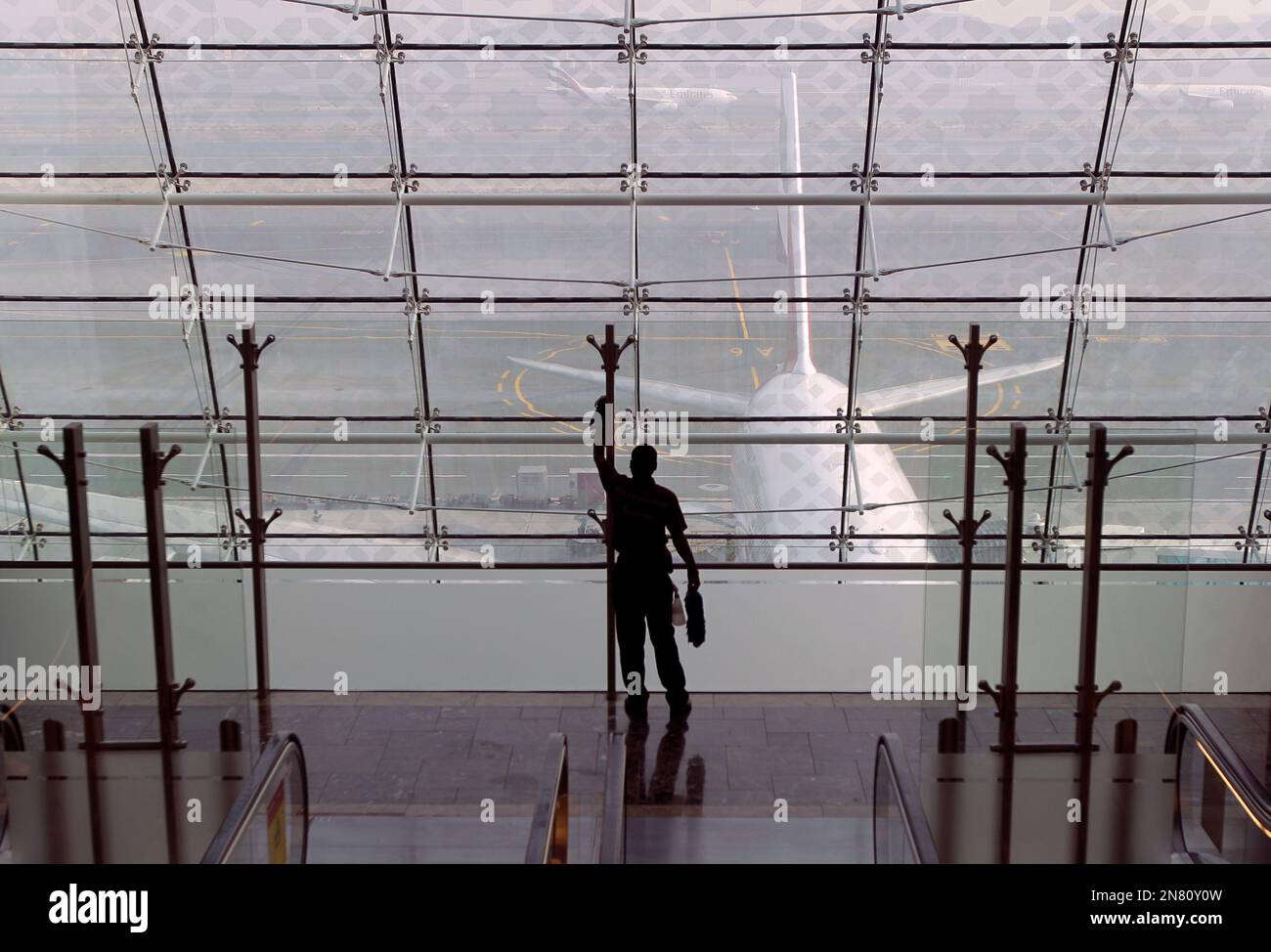 In this Sunday, Feb. 10, 2013, photo a laborer cleans a window at the ...