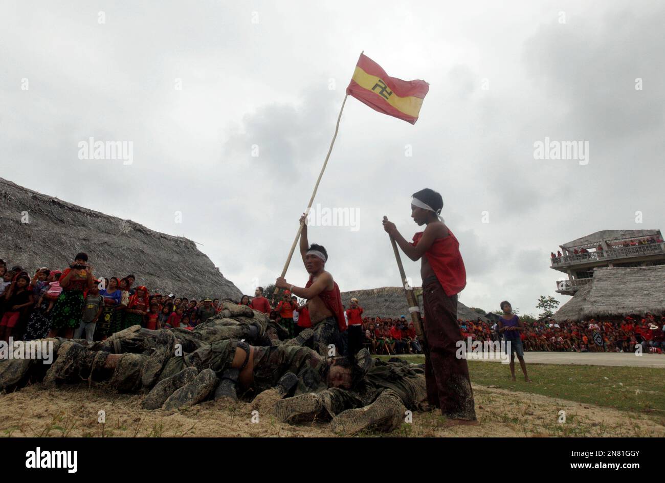 In this Feb. 25, 2013 photo, men put up a flag as they reenact a battle ...
