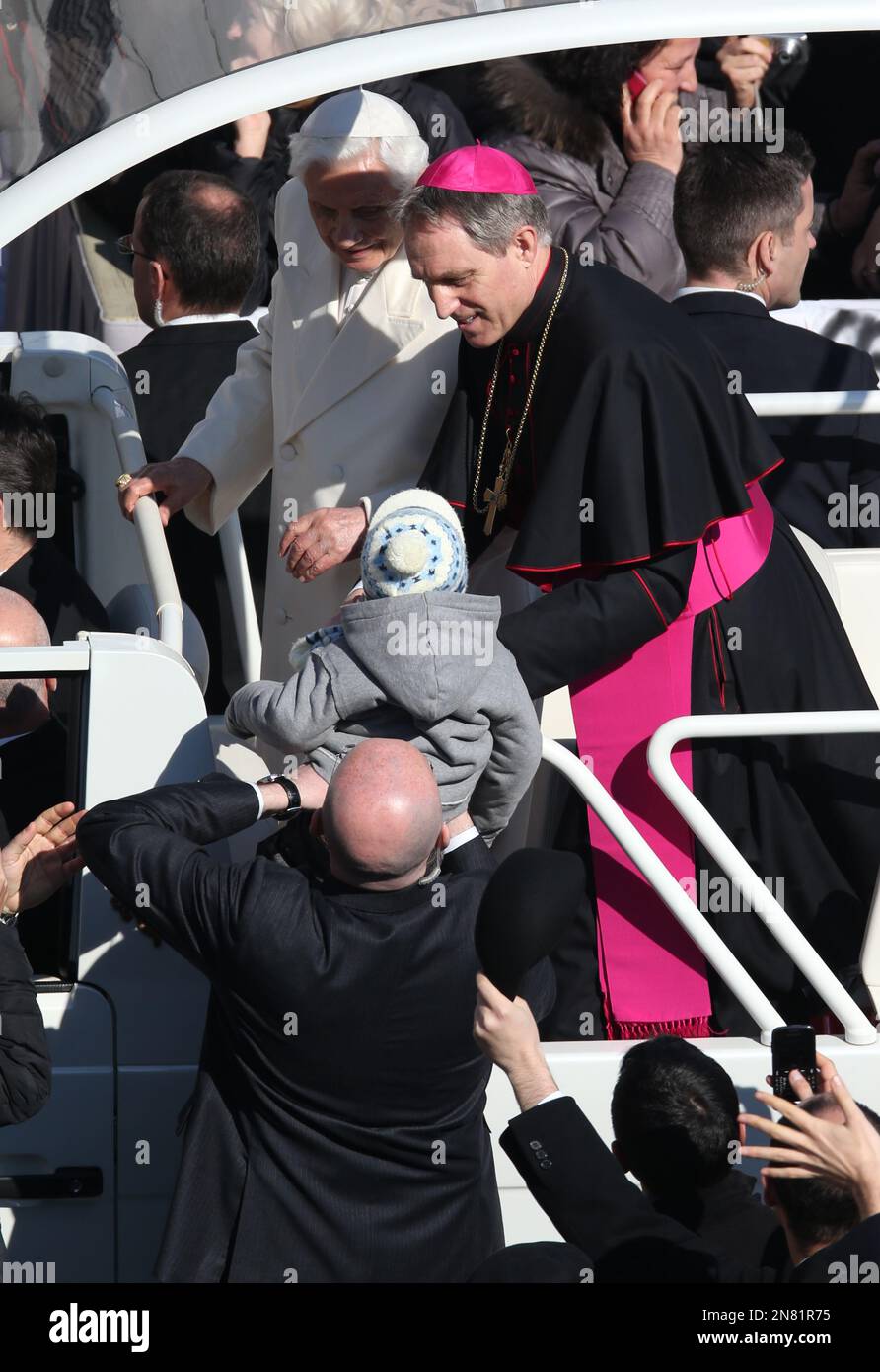 Pope Benedict XVI is handed up a baby as he greets pilgrims in St ...