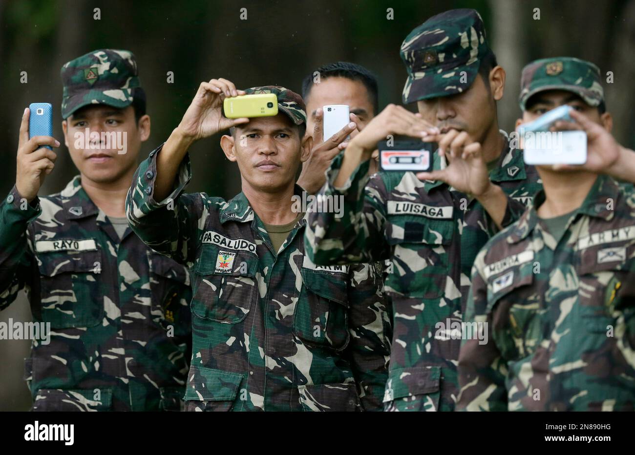 Philippine soldiers take photos of their marching fellow soldiers ...