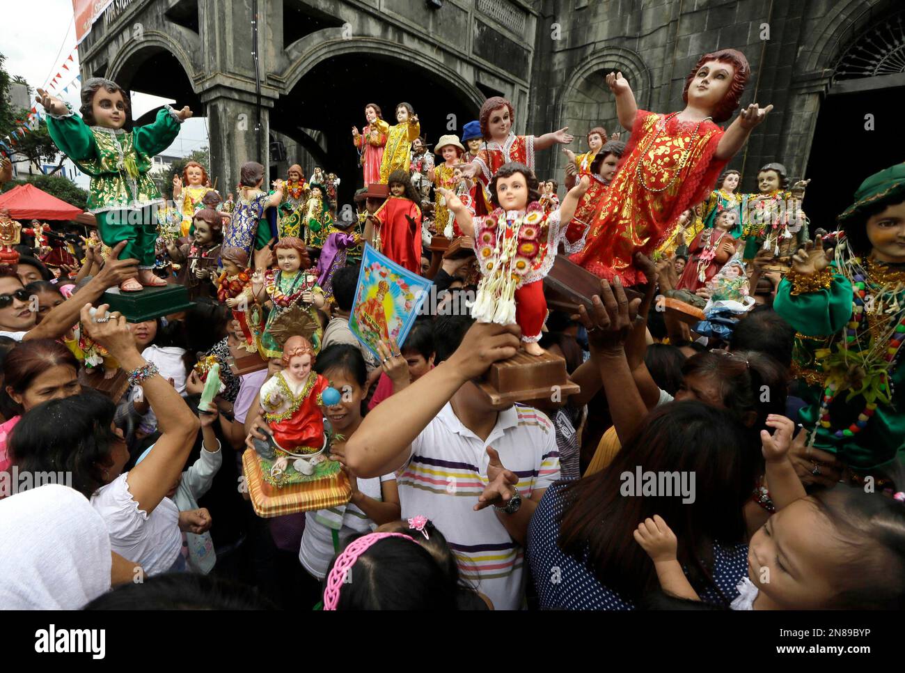 Roman Catholic devotees raise their images of the Infant Jesus for ...