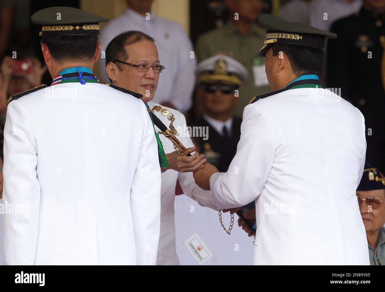 Philippine President Benigno Aquino III, center, hands the ceremonial ...