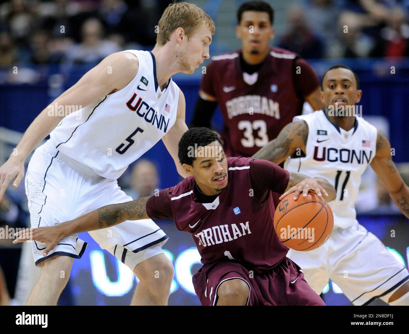 Fordham's Branden Frazier, center, is guarded by Connecticut's Niels ...