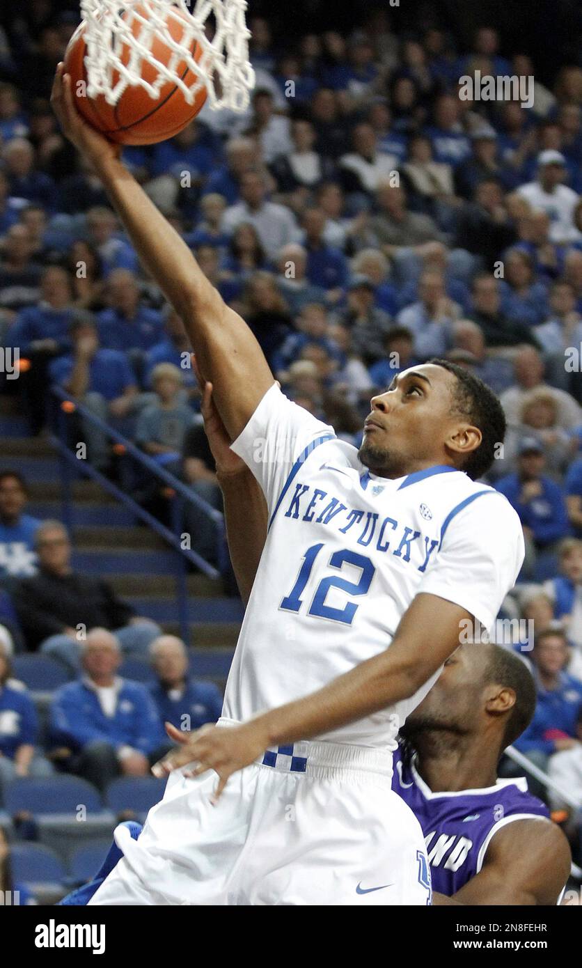 Kentucky's Ryan Harrow (12) shoots next to Portland's Derrick Rodgers ...