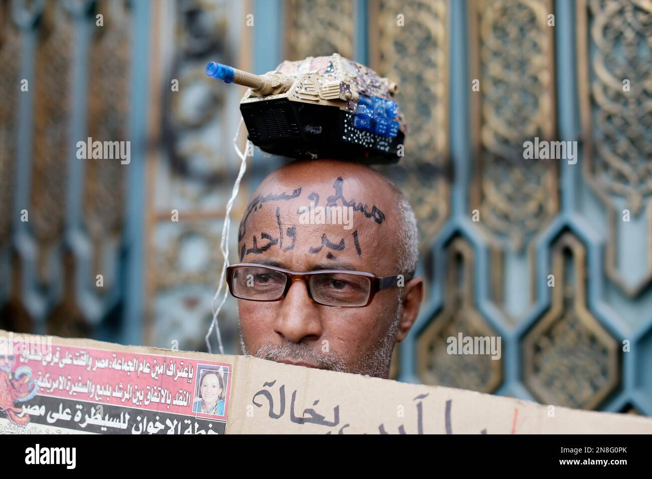 An Egyptian protester with Arabic writing on his forehead that reads ...