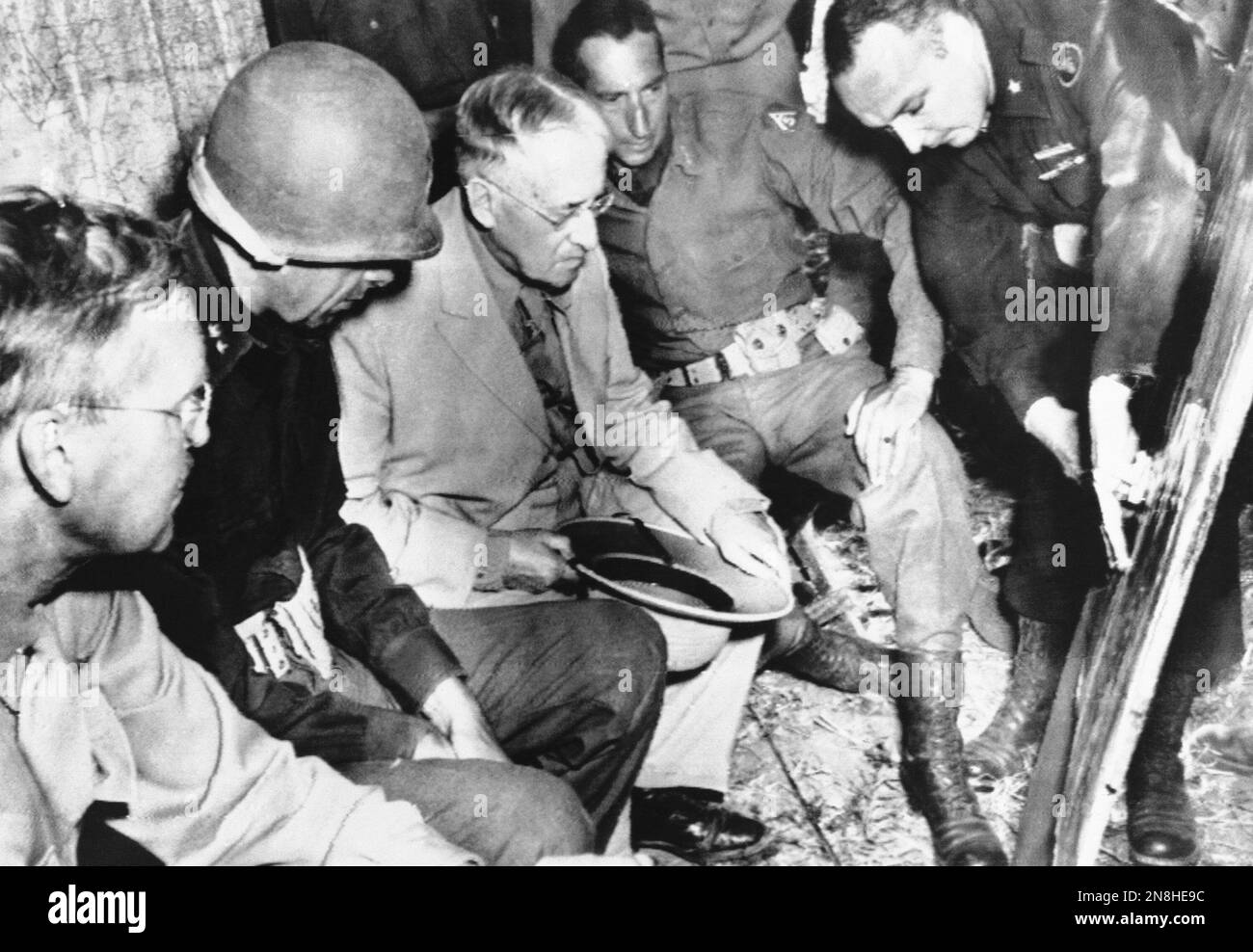 Secretary of War Henry L. Stimson, center, holding pith helmet, studies ...