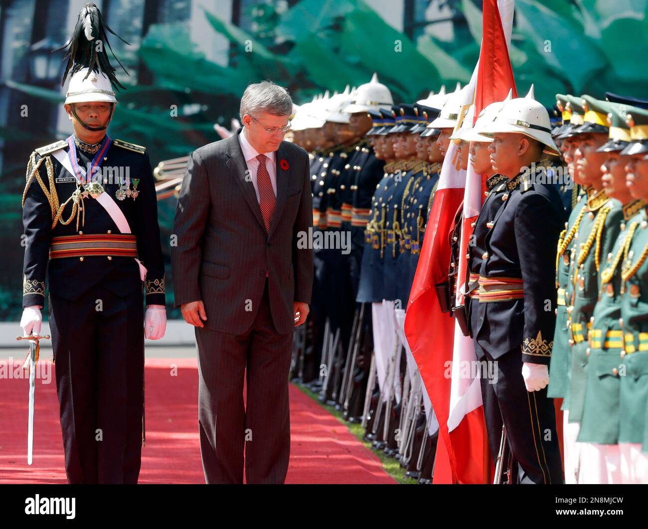 Visiting Canadian Prime Minister Stephen Harper, center, takes a bow ...