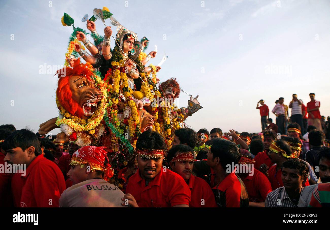 Hindu devotees carry an idol of Hindu goddess Durga for immersion into ...