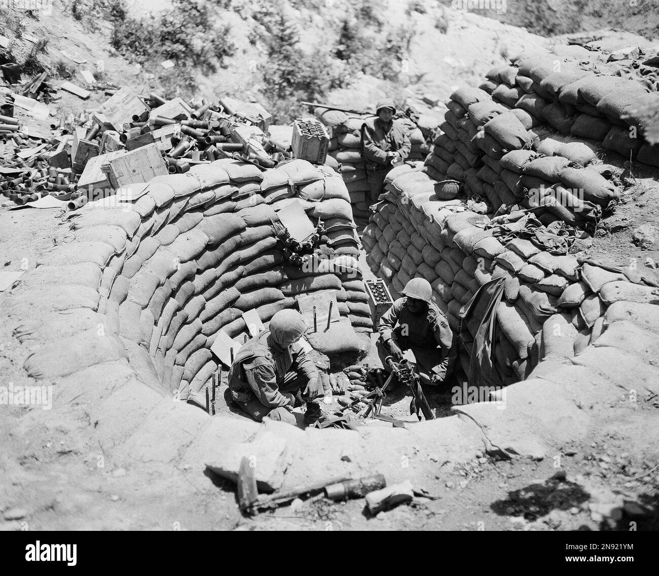 American soldiers sit alongside their 60mm mortar gun in a deep ...