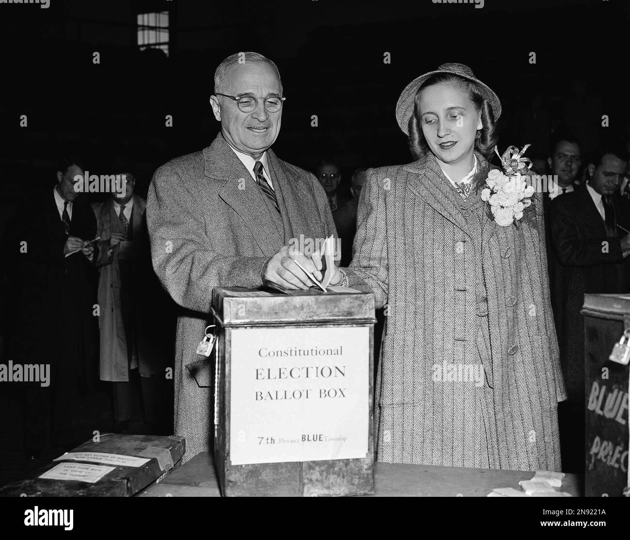 President Truman drops his ballot in a box while his daughter Mary ...