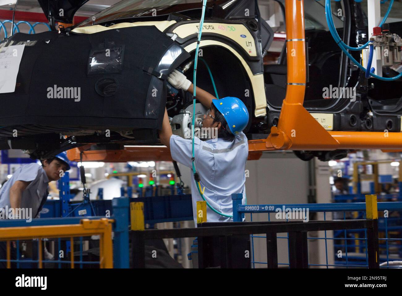 Thai Ford Manufacturing employees work on an assembly line Friday, Aug ...