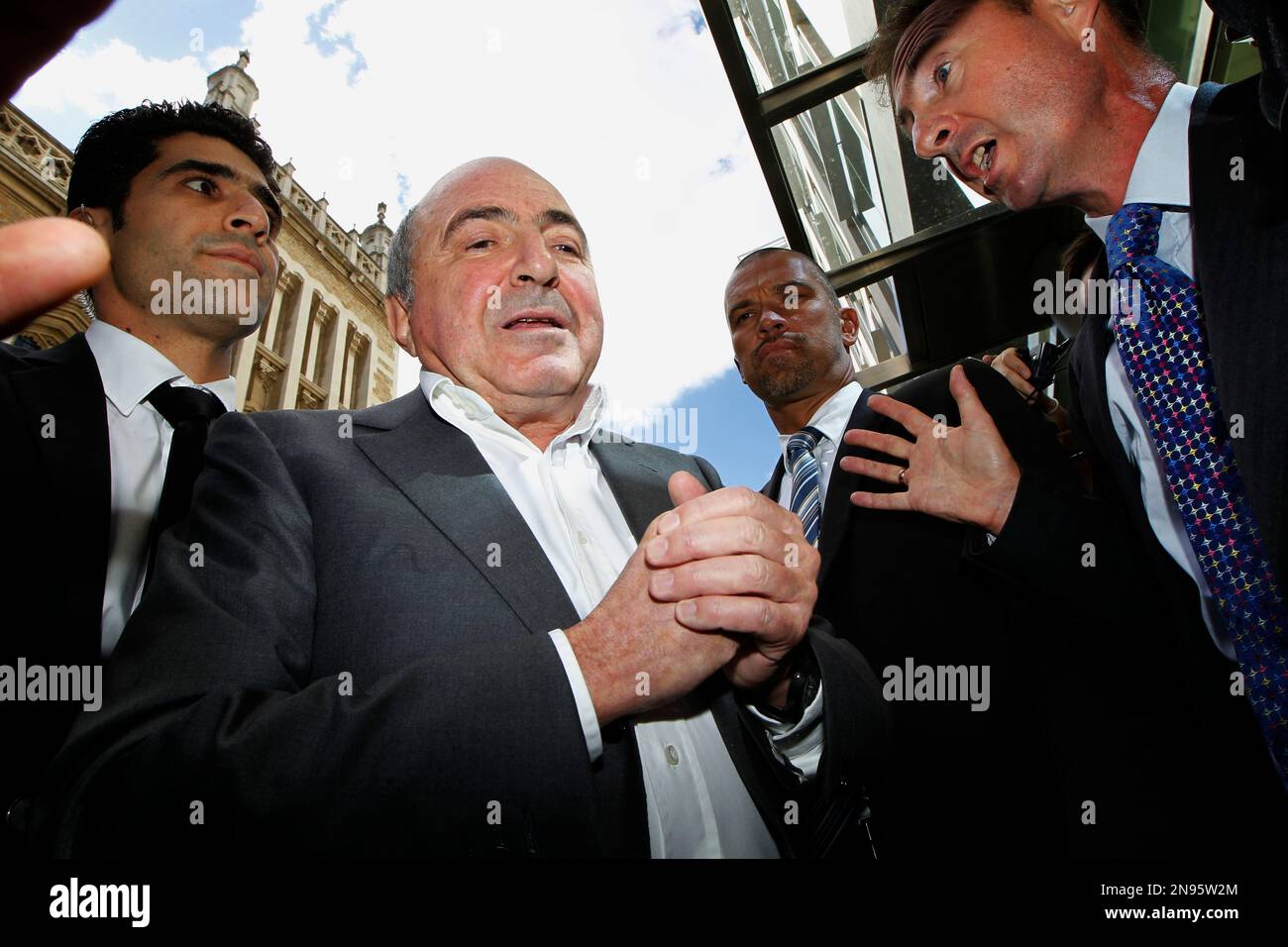 Russian tycoon Boris Berezovsky, second from left, talks to a reporter ...