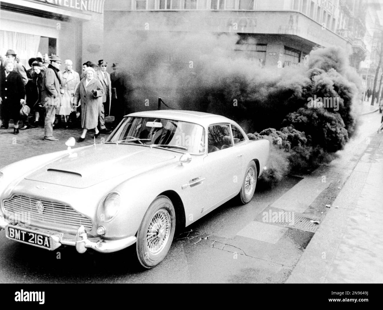 Startled passers by stop and watch as thick black smoke billows from a ...