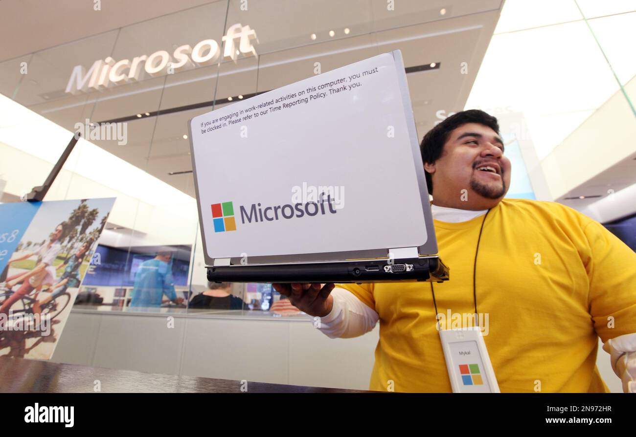 Microsoft store employee Mykal Carlton picks up his laptop sporting the ...