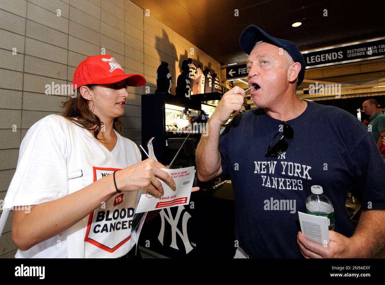 Michael Rowan, right, swabs the inside of his cheek under supervision ...