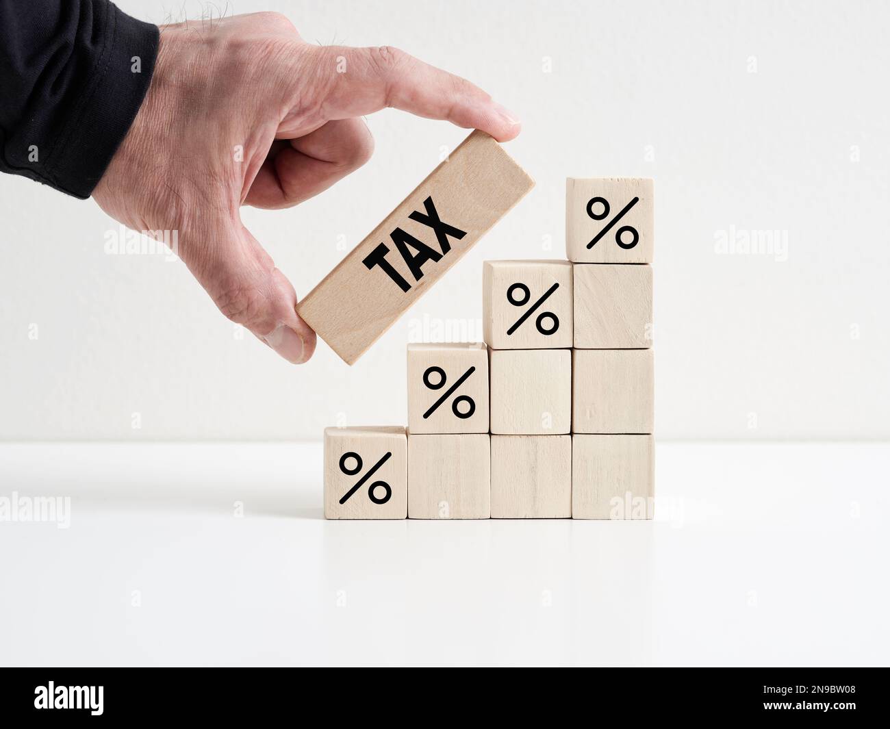 Augmentation d'impôt ou inflation d'impôt. Main place un bloc de bois ...