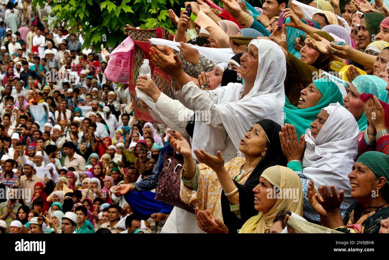 Kashmiri Muslims pray as the head priest, unseen, displays a relic of ...
