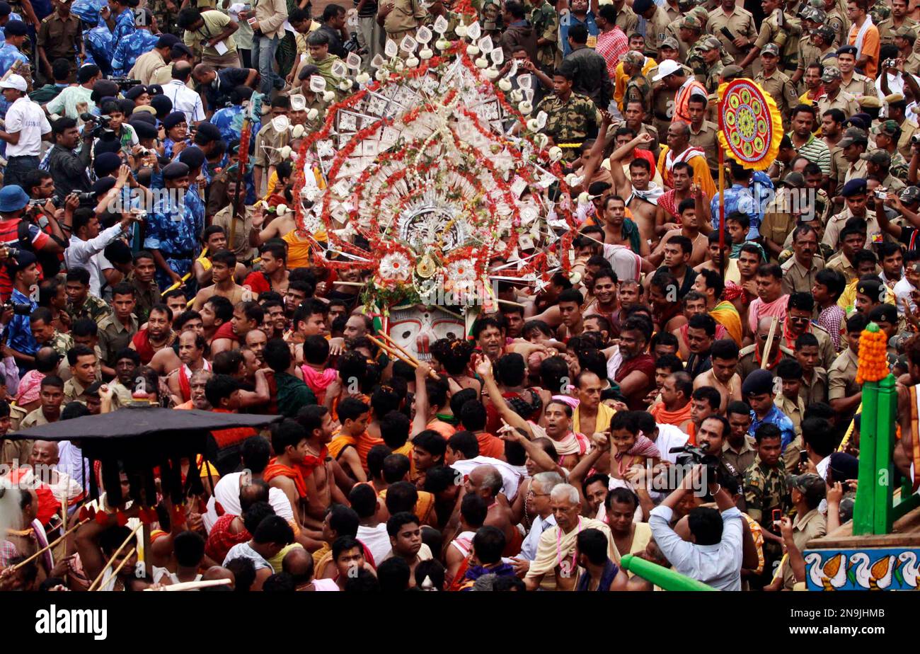 Hindu devotees and temple priests gather around an idol of a Hindu God ...