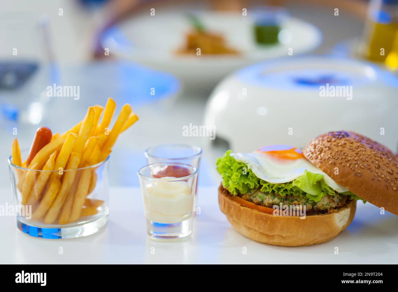 Gros plan du petit déjeuner hamburger avec pain au sésame sur le côté ...