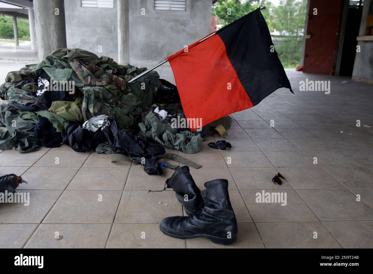 Army boots, uniforms and a flag are gathered in a pile inside a former ...