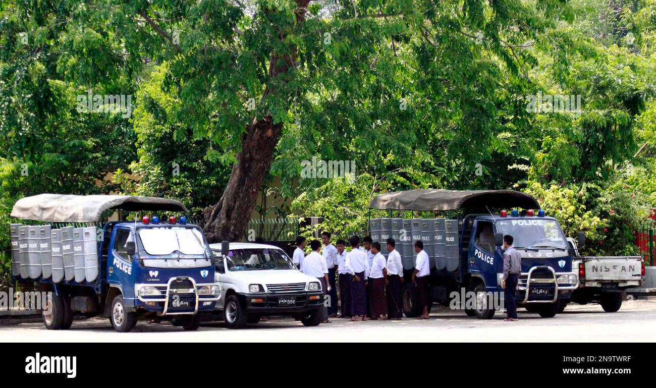 Myanmar plainclothes police officers gather around police trucks parked ...